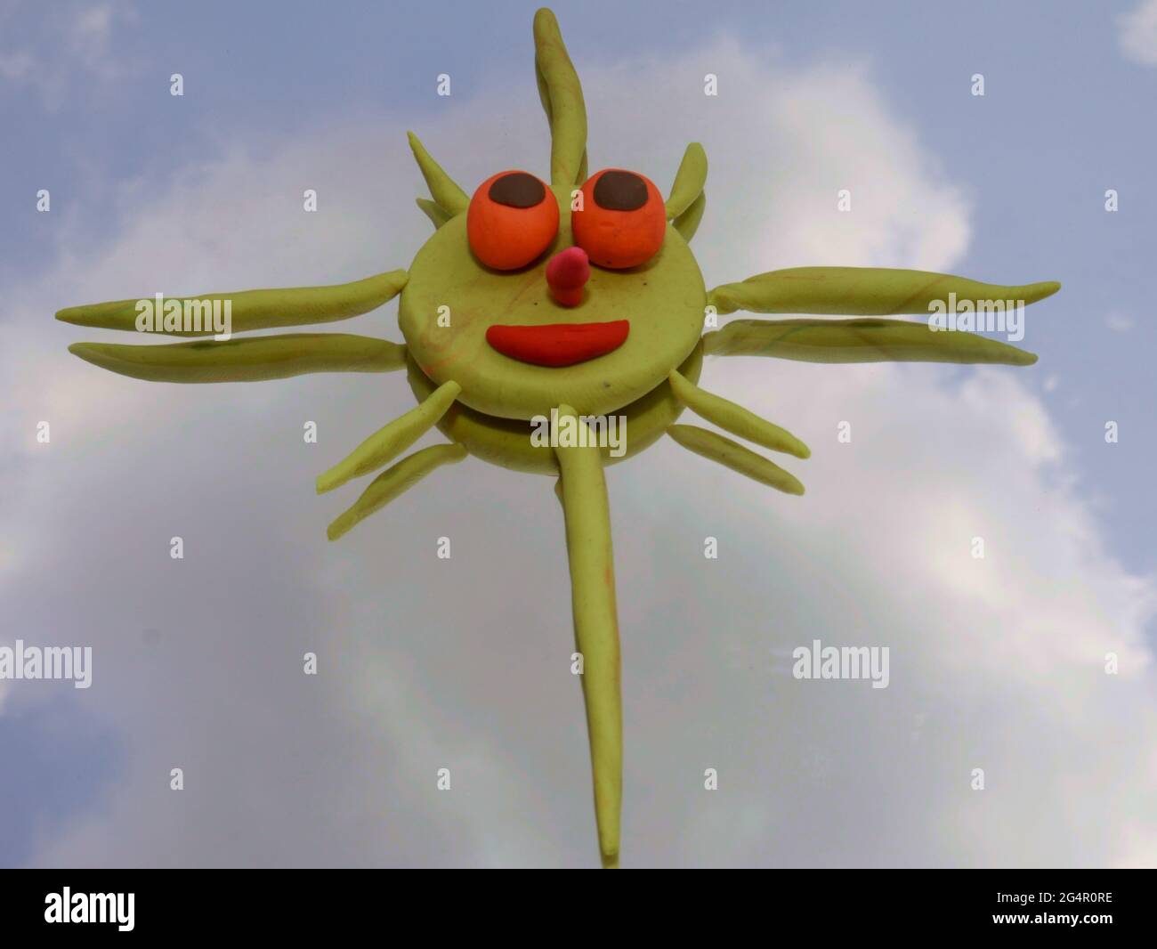 Clay made sun cartoon eyes with smiling face isolate Stock Photo - Alamy