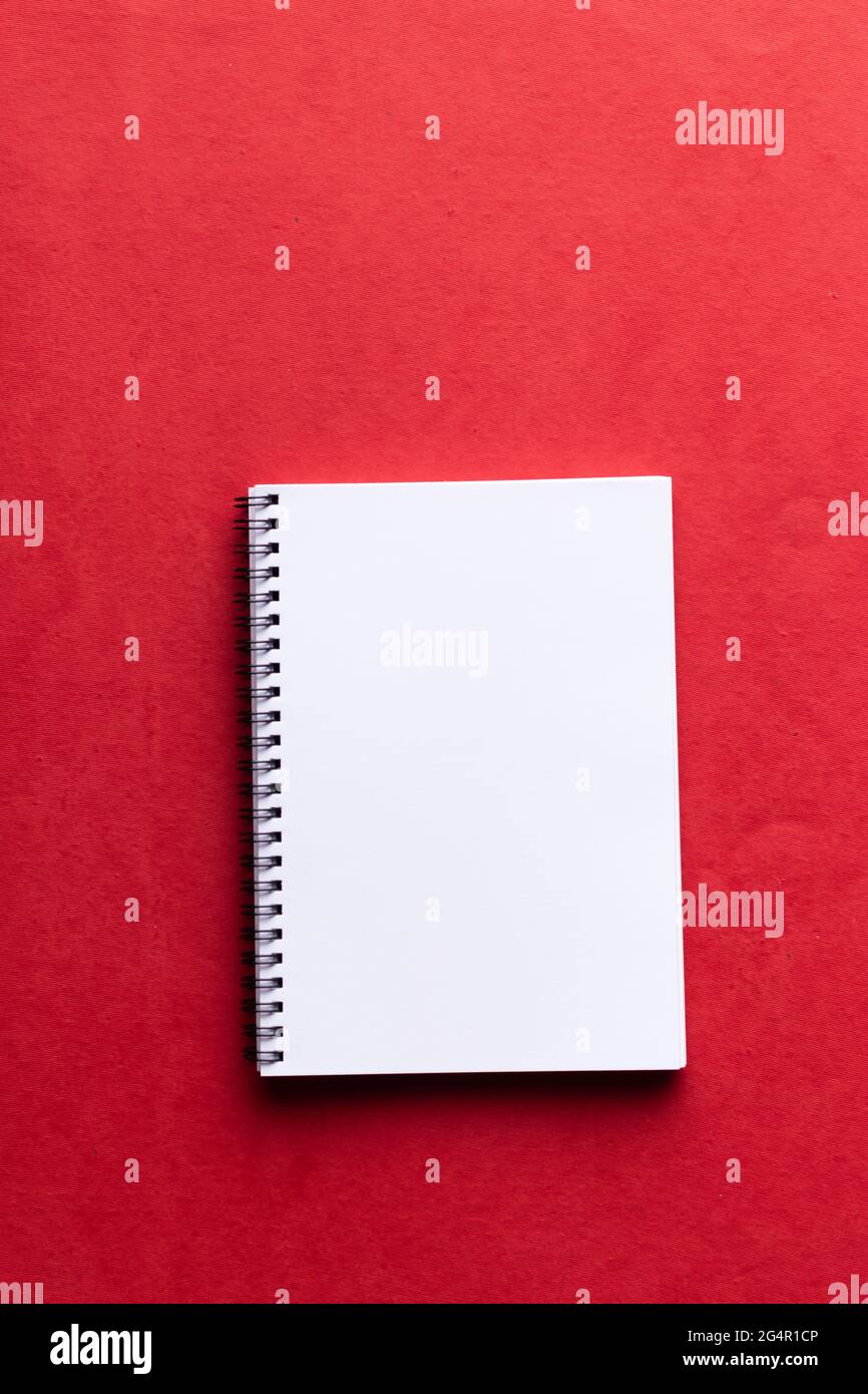 A notebook of white page kept on a red background Stock Photo - Alamy