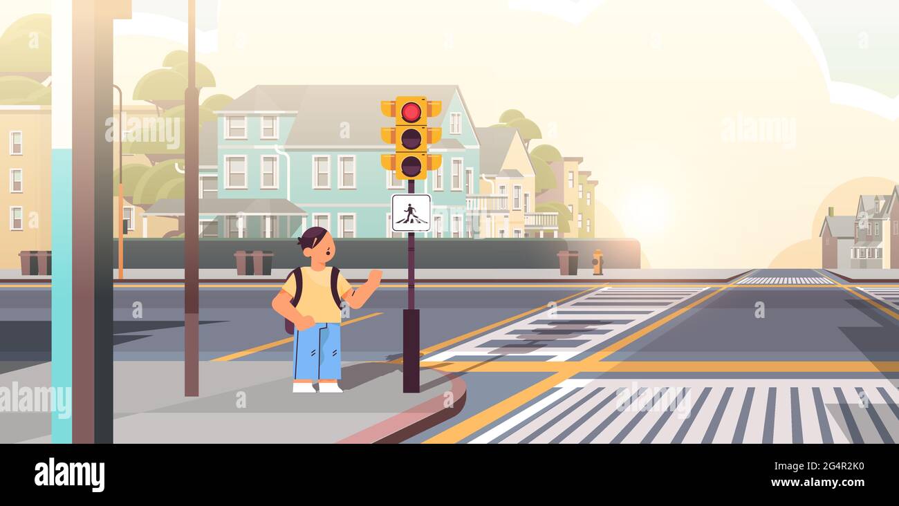 schoolboy with backpack waiting for green traffic light to cross road ...