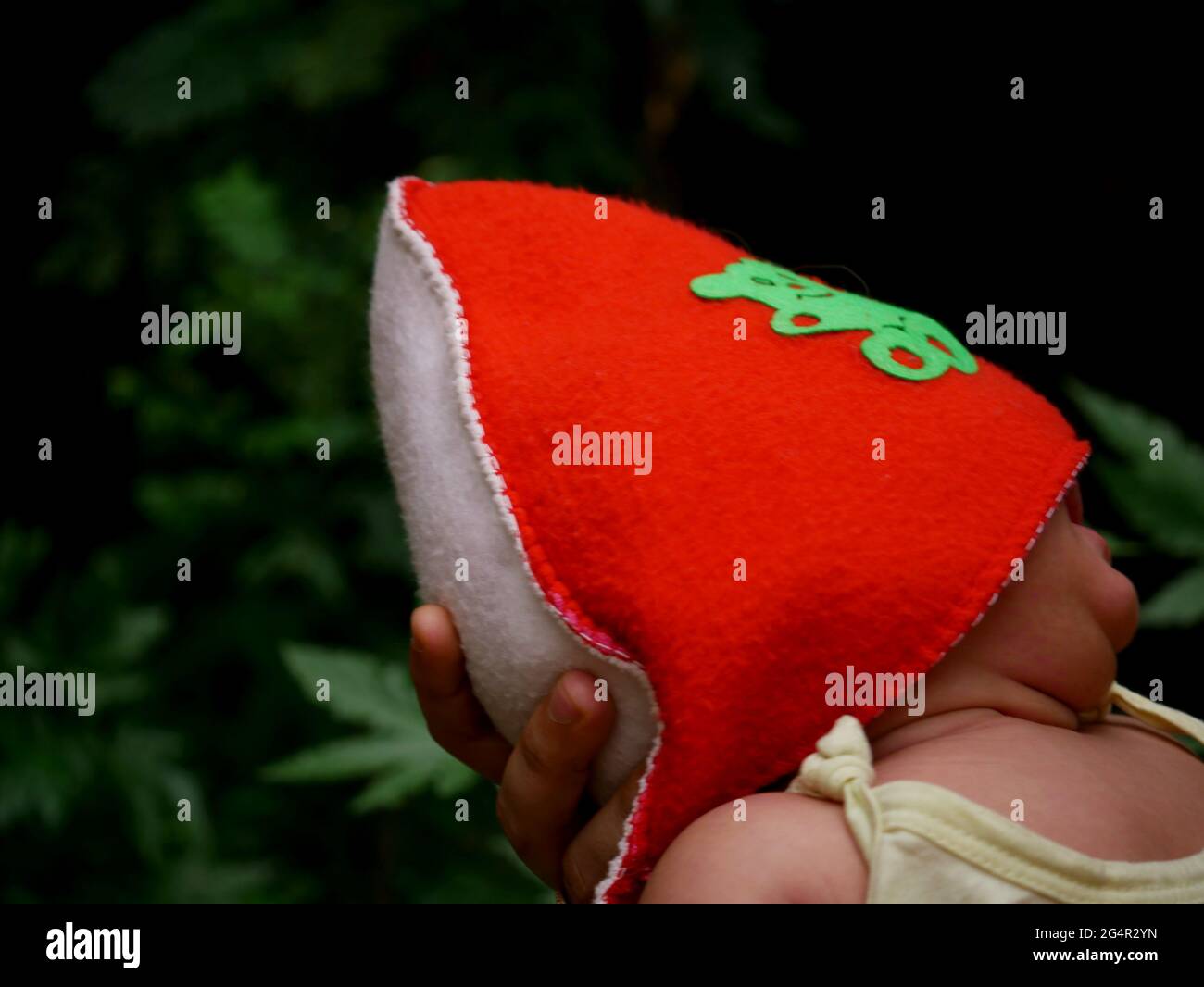 Cute baby wearing red color cap holding by mother hand on nature ...