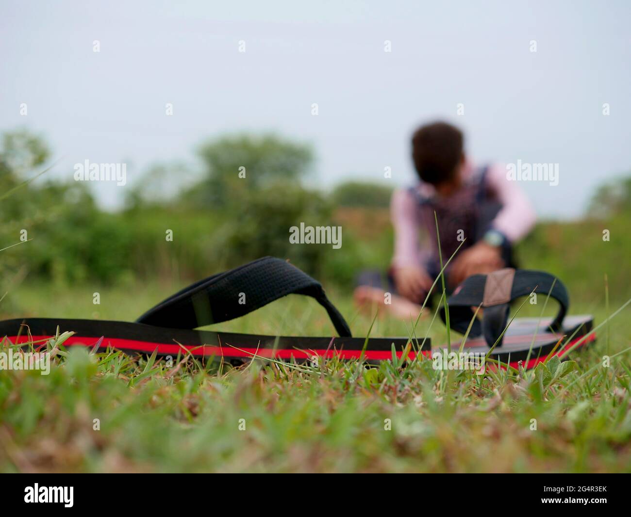 Red black color foot sleeper closeup shot behind blur boy seating on ...