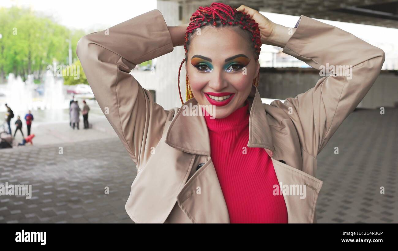 Fashionable girl in an elegant beige jacket with multi-colored African ...