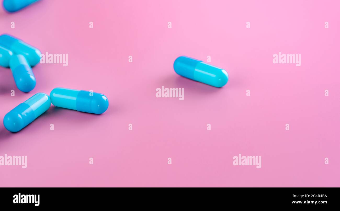 Blue capsule pills on pink background. Blue capsule pills with space ...