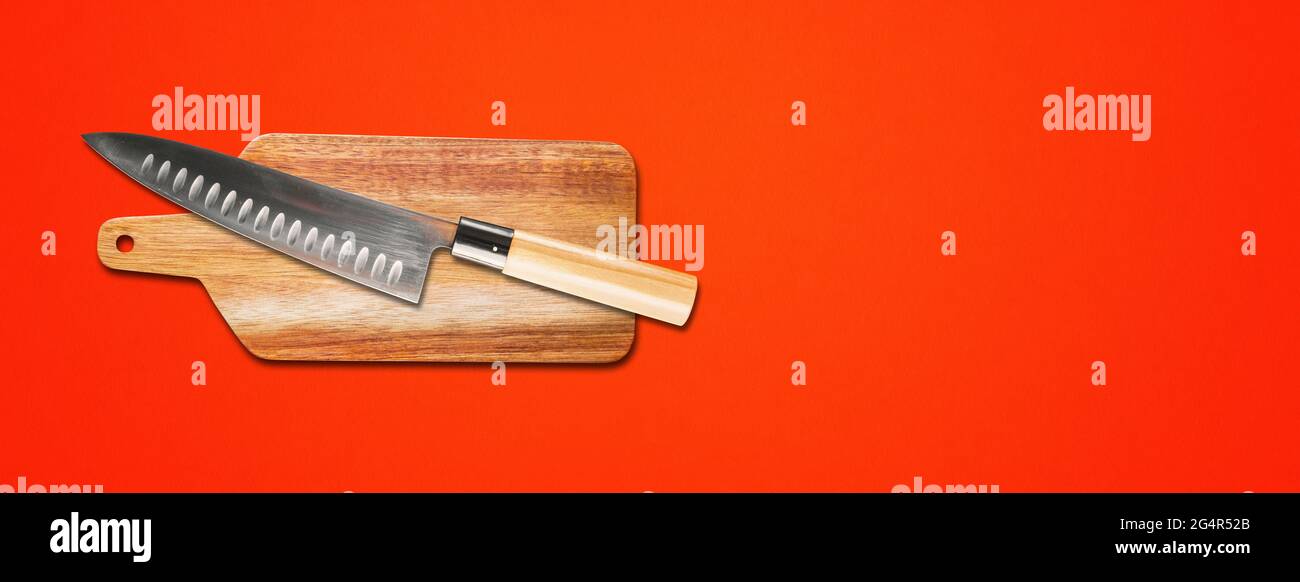 Traditional Japanese gyuto chief knife on a cutting board. Red banner ...