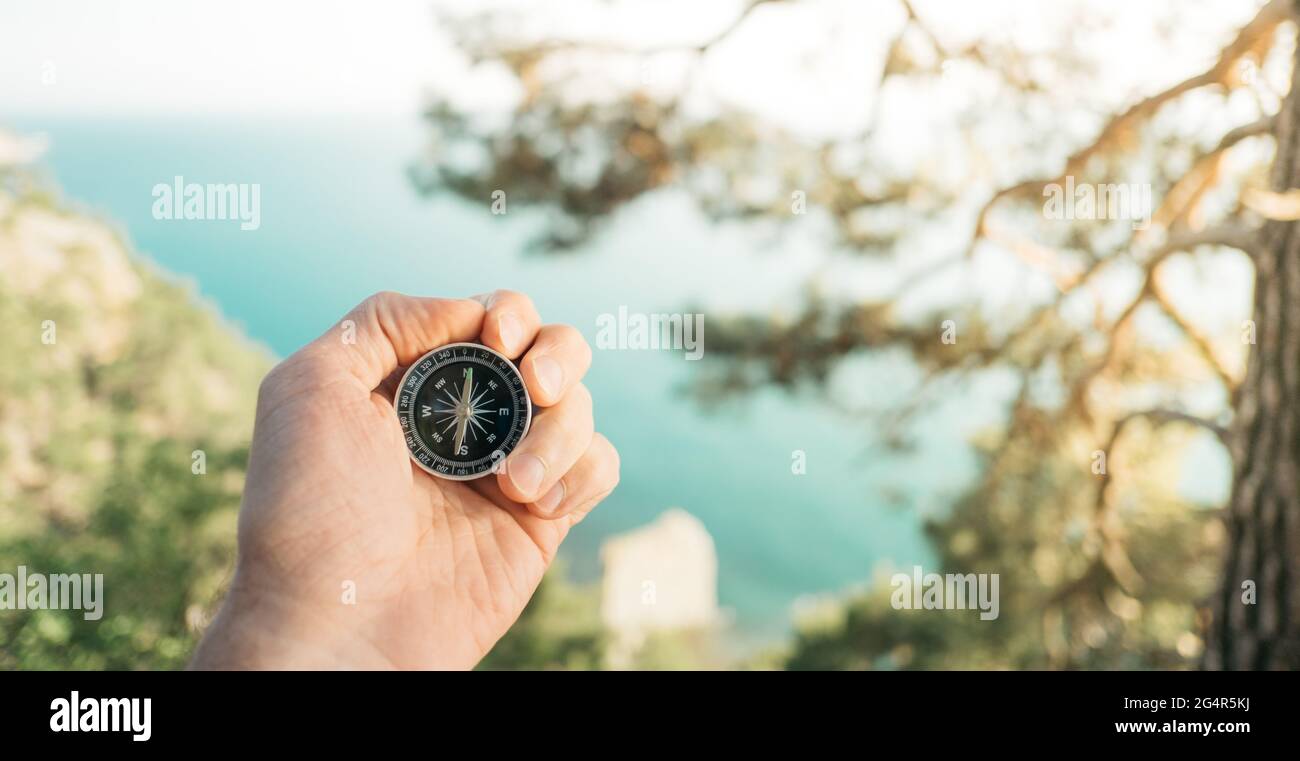 Male traveler with a compass in his hand Stock Photo - Alamy