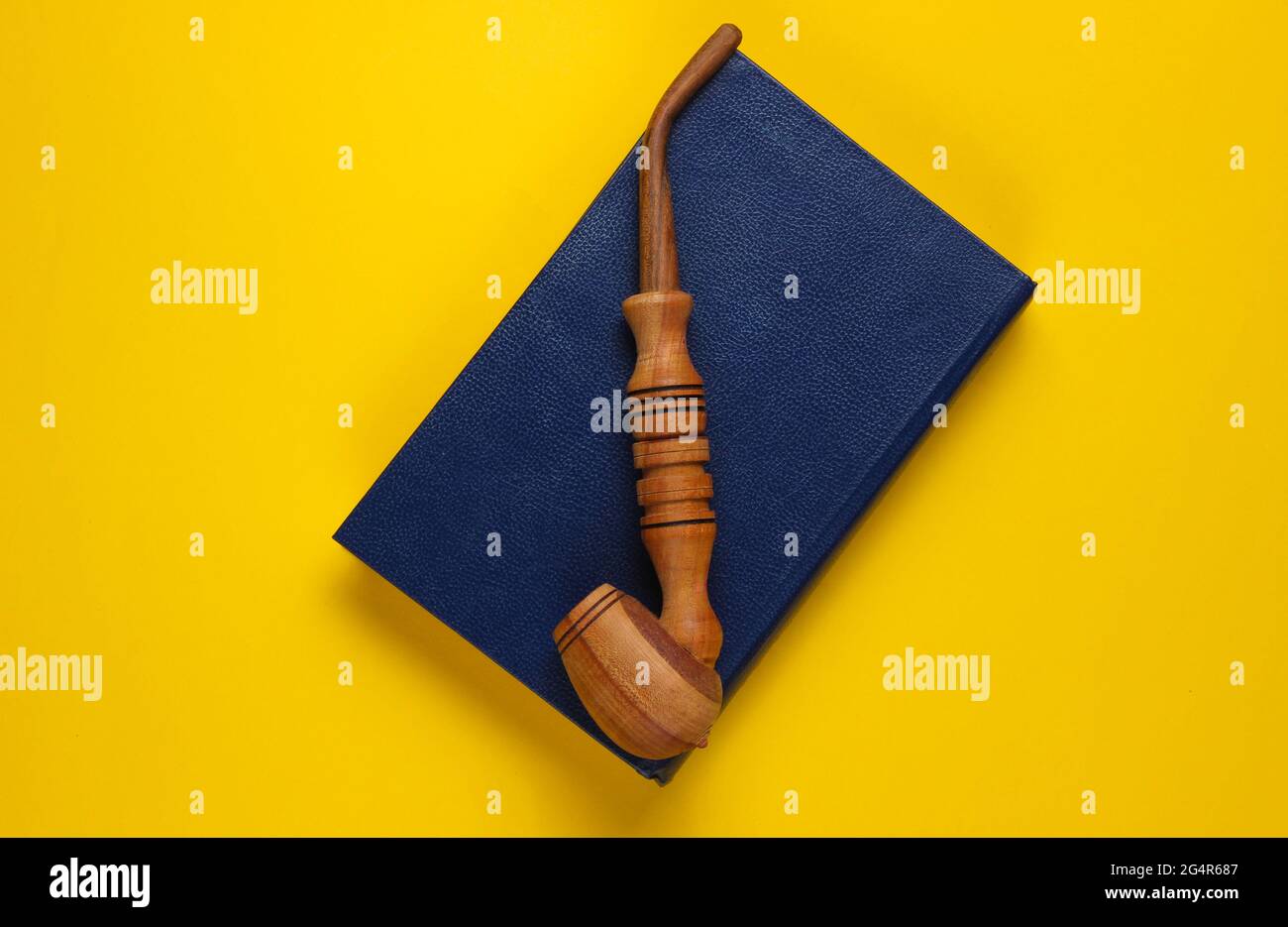 Vintage style. Old book, smoking pipe on yellow background. Top view ...