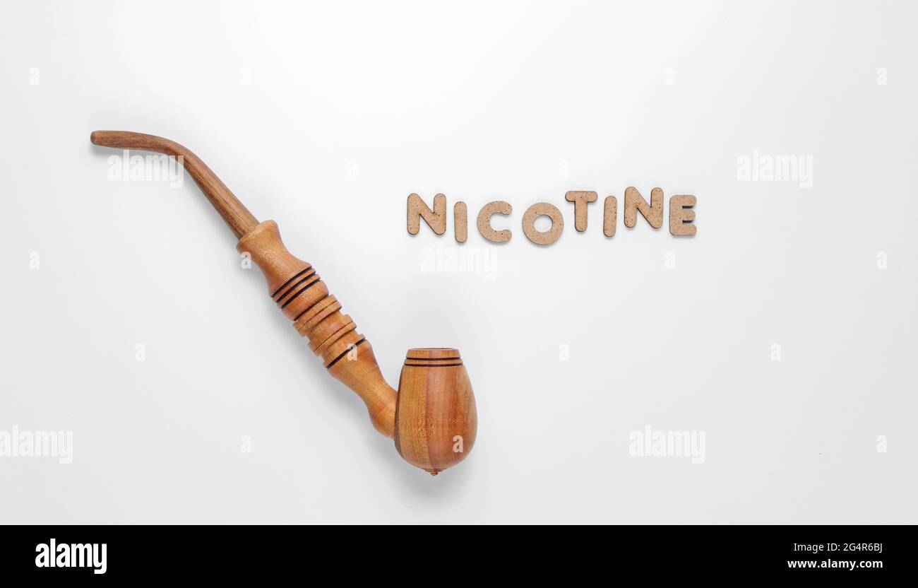 Wooden smoking pipe on white background with word nicotine of wooden ...