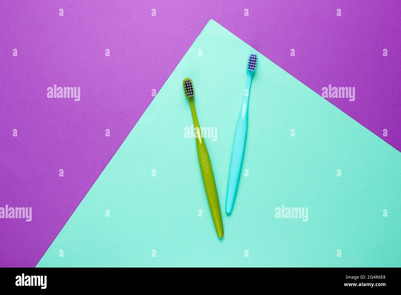 Two new toothbrushes on purple blue paper background. Minimalism ...