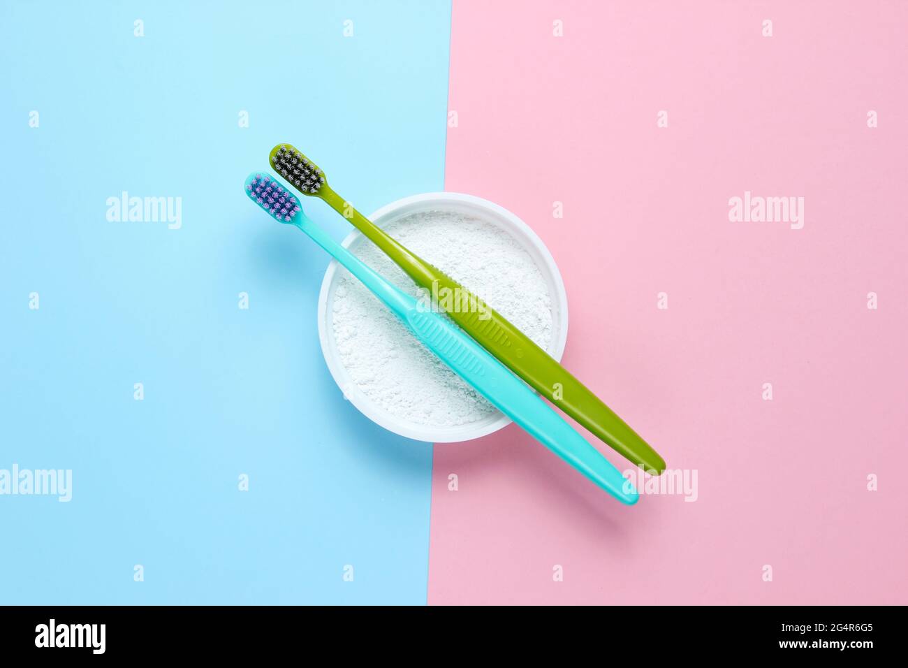 Two toothbrushes, tooth powder on pink blue pastel background ...