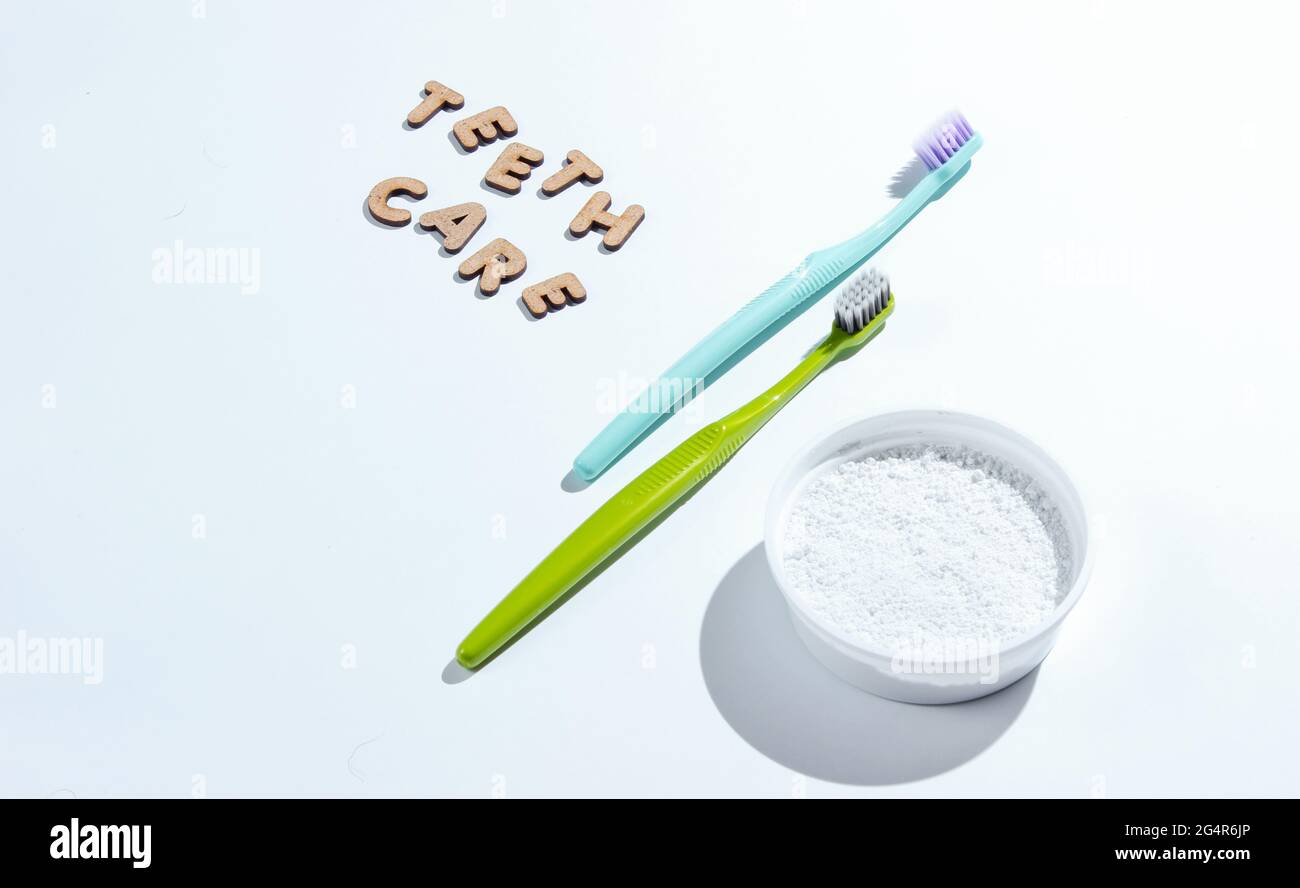 Two toothbrushes, tooth powder on white background with slogan teeth ...