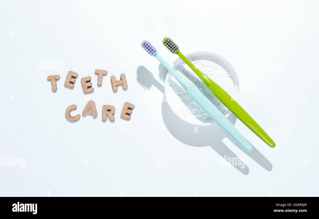 Two toothbrushes, tooth powder on white background with slogan teeth ...