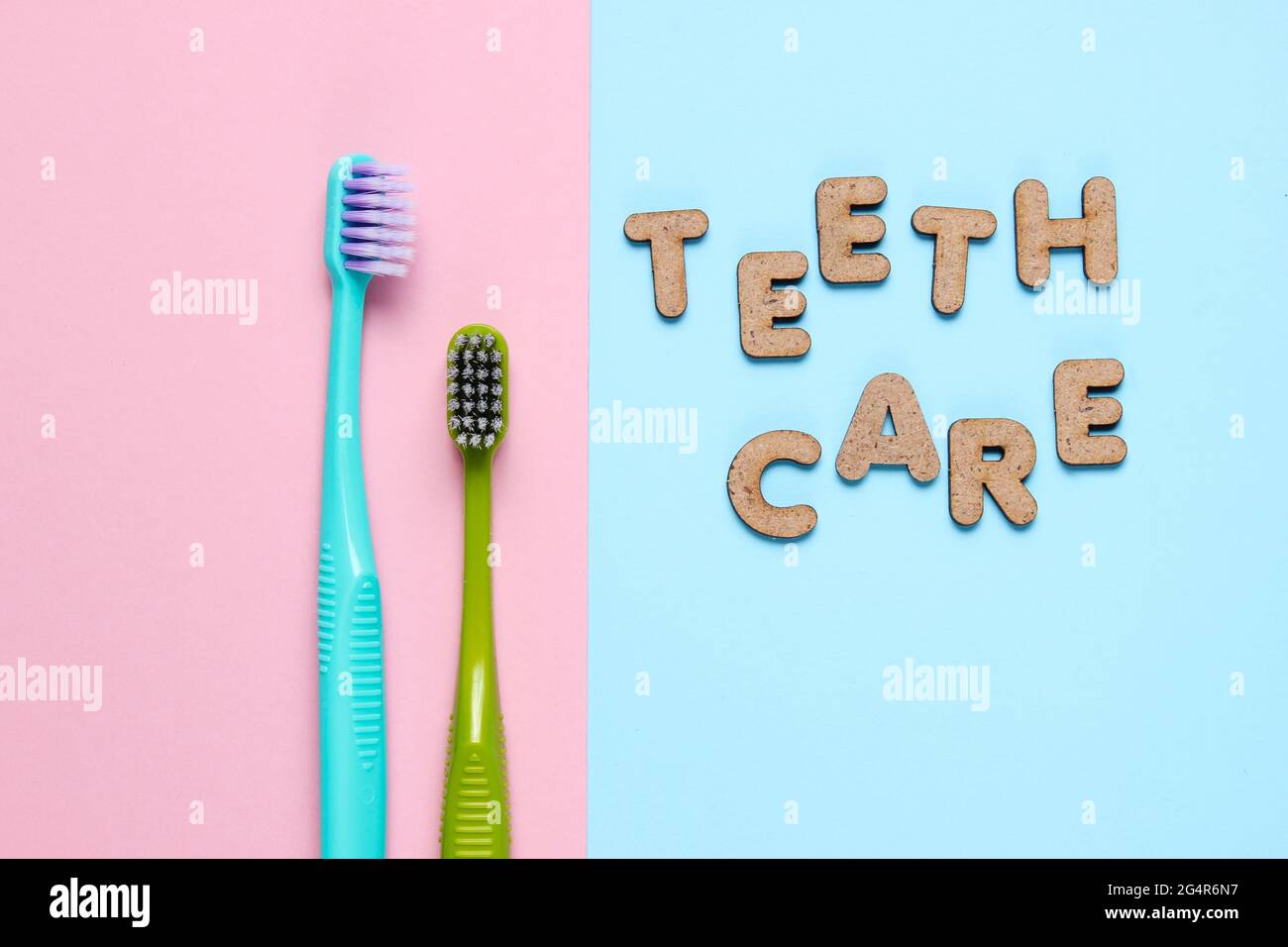 Two toothbrushes on blue pink pastel background with slogan teeth care ...