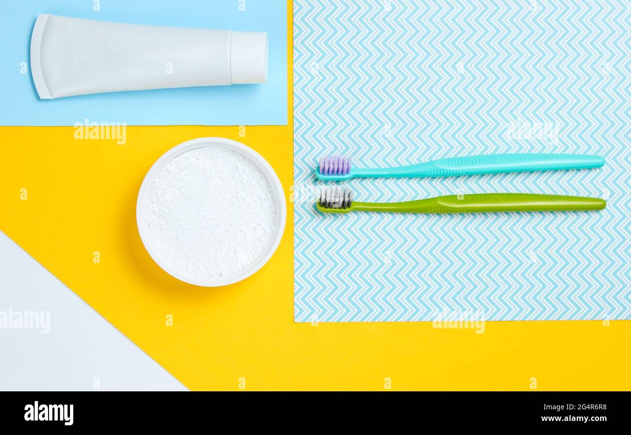 Minimalistic oral hygiene concept. Two toothbrushes with a tube of ...