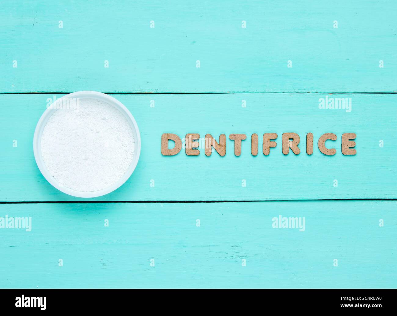 Tooth powder on a blue background with word dentifrice. Minimalistic ...