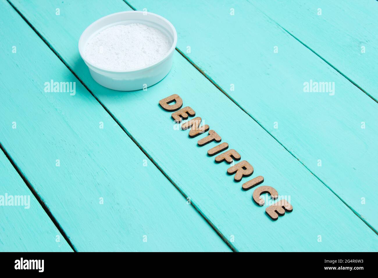 Tooth powder on a blue background with word dentifrice. Minimalistic ...