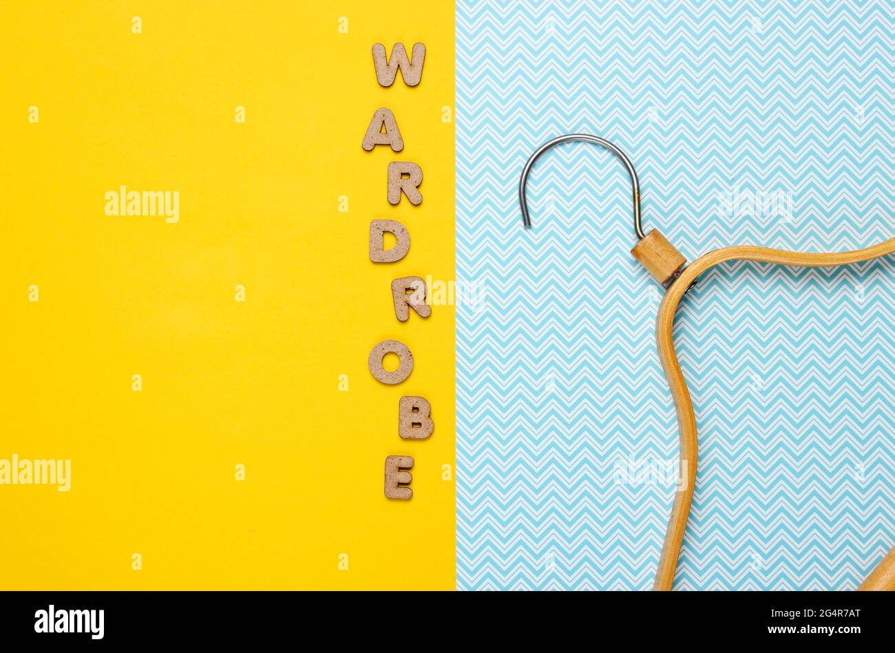 Wooden hanger on a yellow blue background with the word wardrobe. Top ...