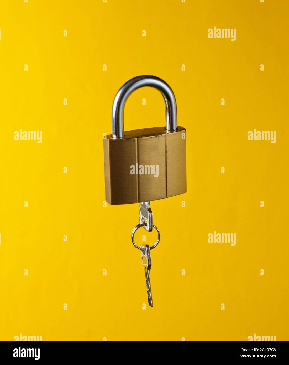 Metal lock with key on yellow background Stock Photo - Alamy