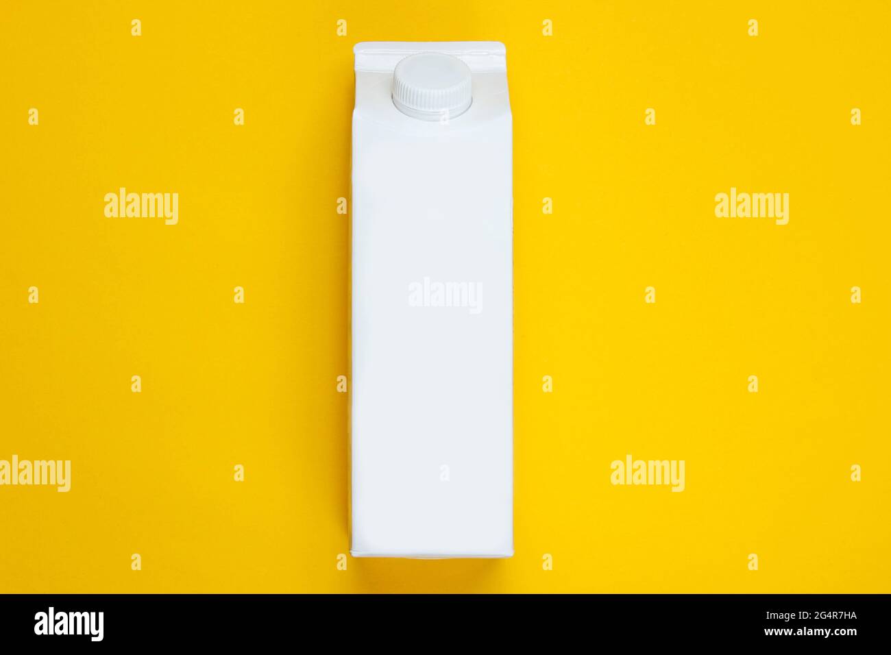 White cardboard box of yogurt on a yellow background. Minimalistic eco ...