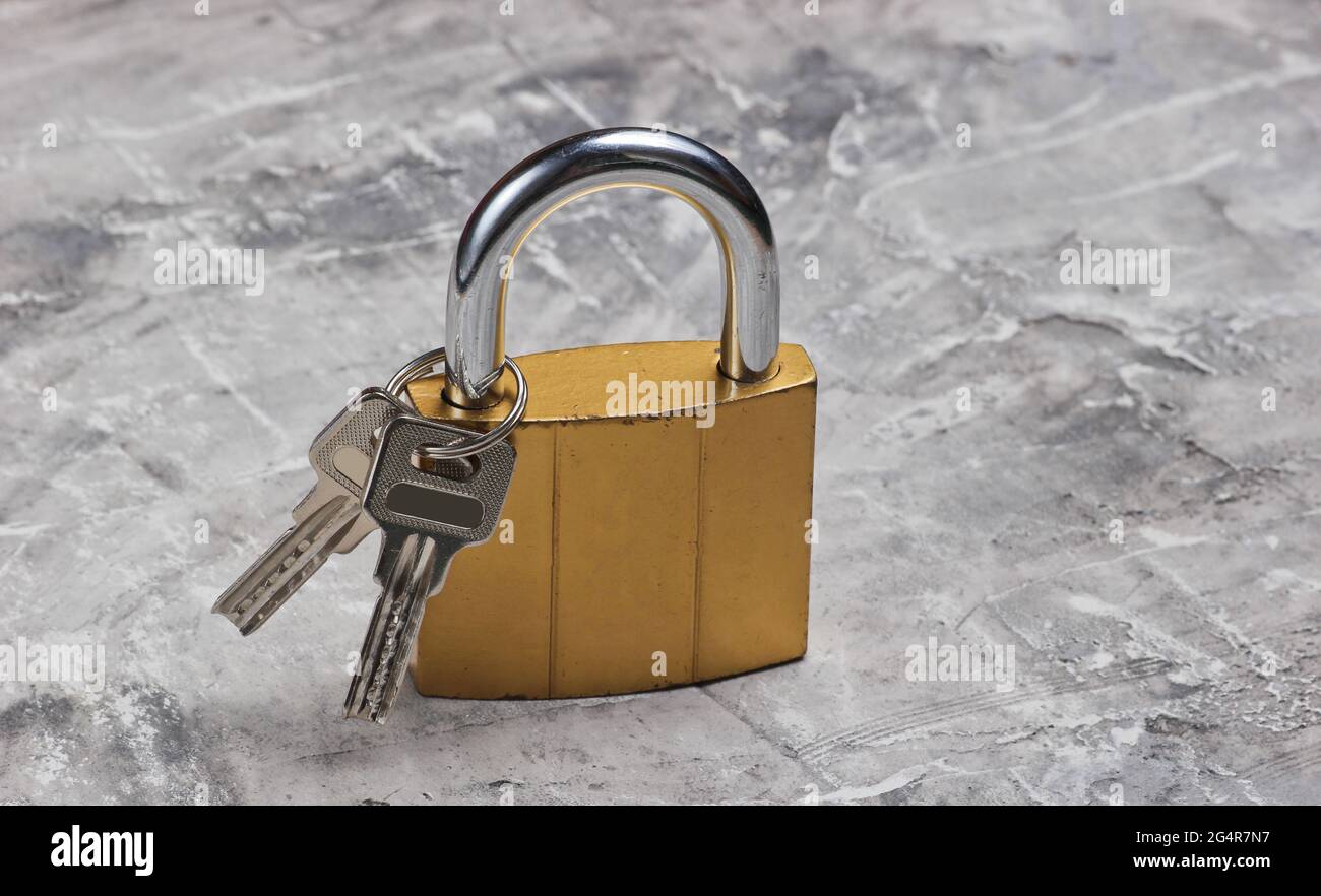 Metal lock with keys on gray concrete background Stock Photo - Alamy