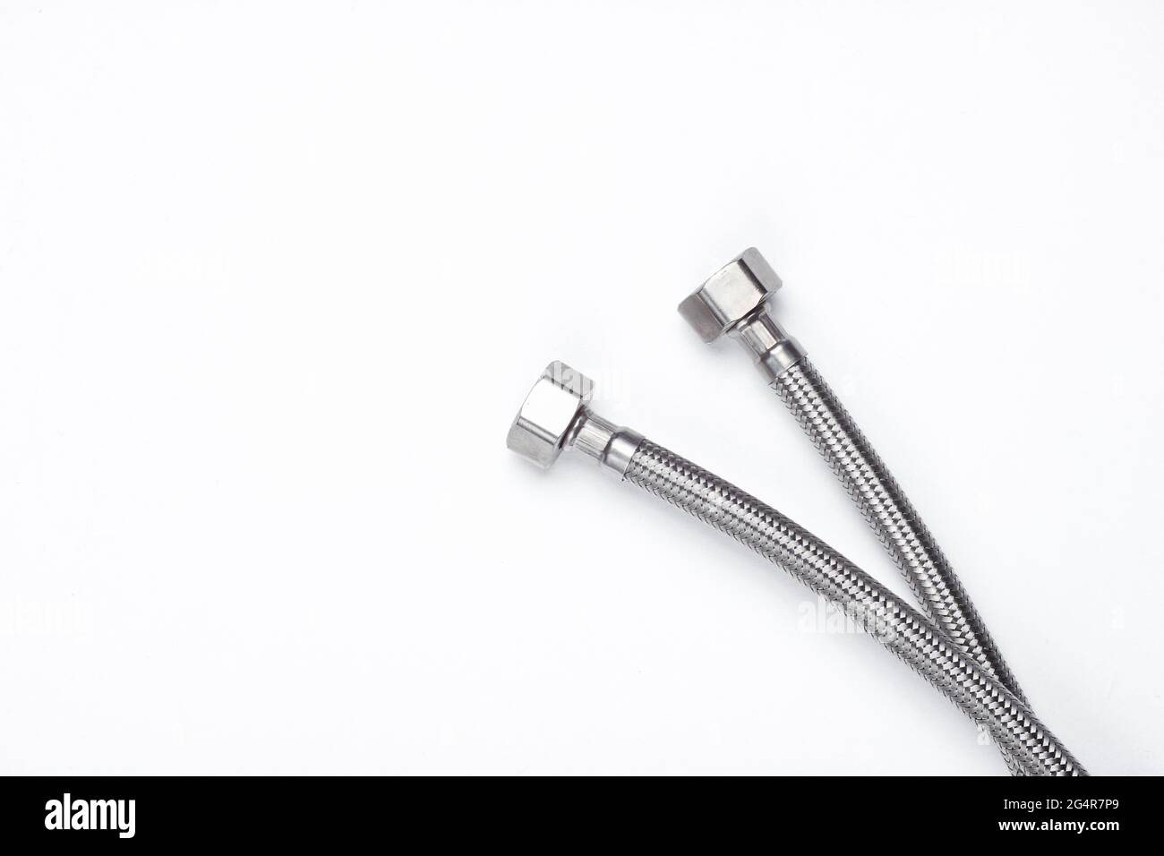 Two metal plumbing hoses on a white background Stock Photo - Alamy