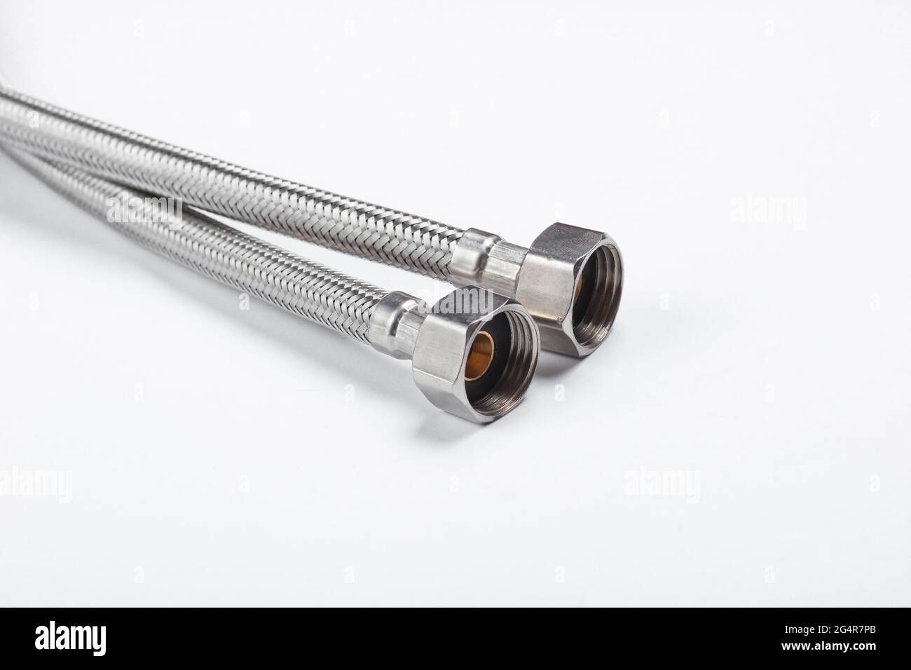Two metal plumbing hoses on a white background Stock Photo - Alamy