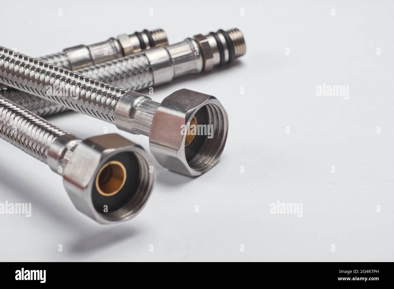 Two metal plumbing hoses on a white background Stock Photo - Alamy