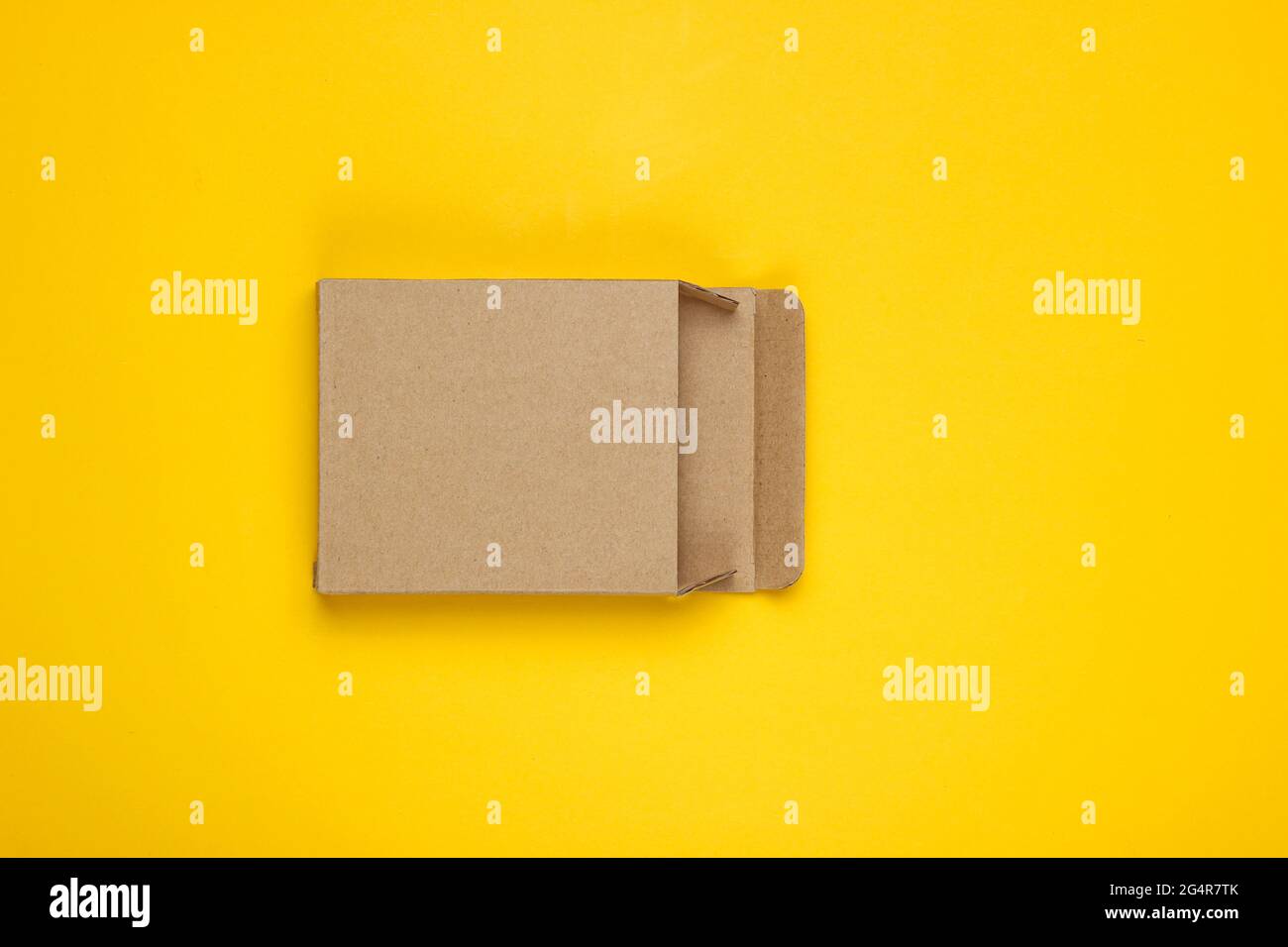 Empty cardboard box on yellow paper background Stock Photo - Alamy