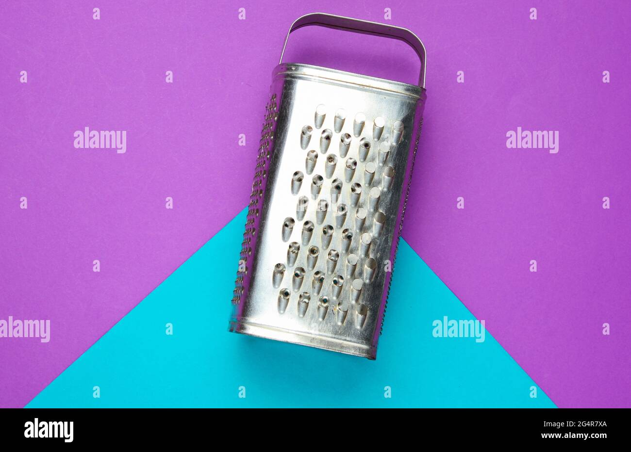 Metal grater on a blue-purple background. Minimalistic food concept ...