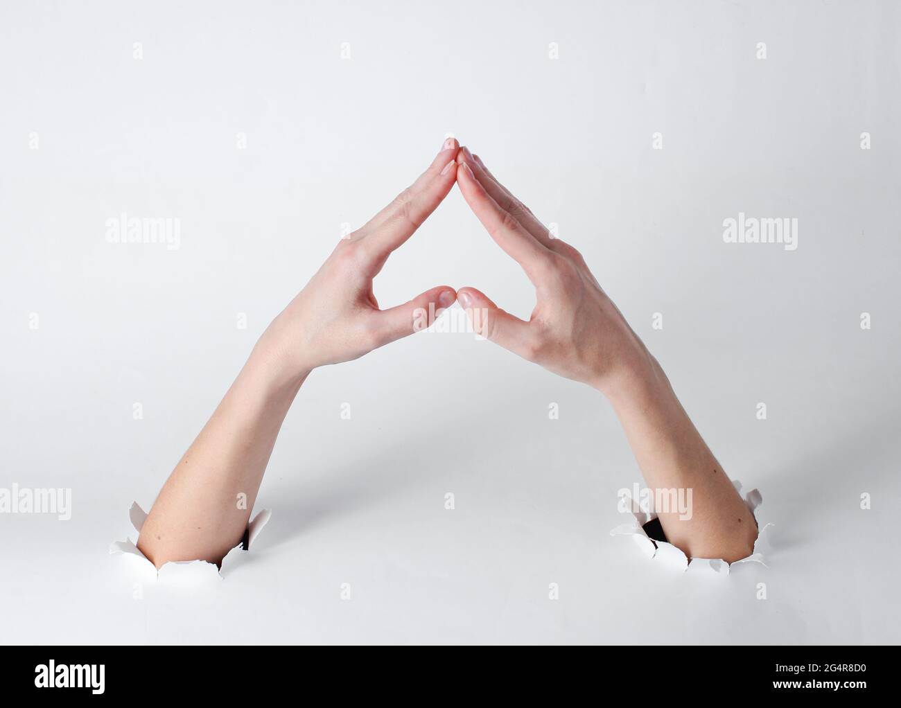 Women's hands are reduced to a pyramid through the torn holes of a ...