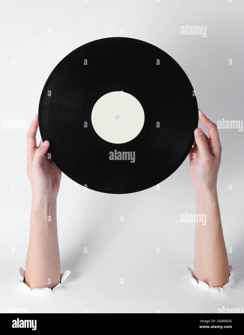 Female hands holding a vinyl record through the torn holes of white ...