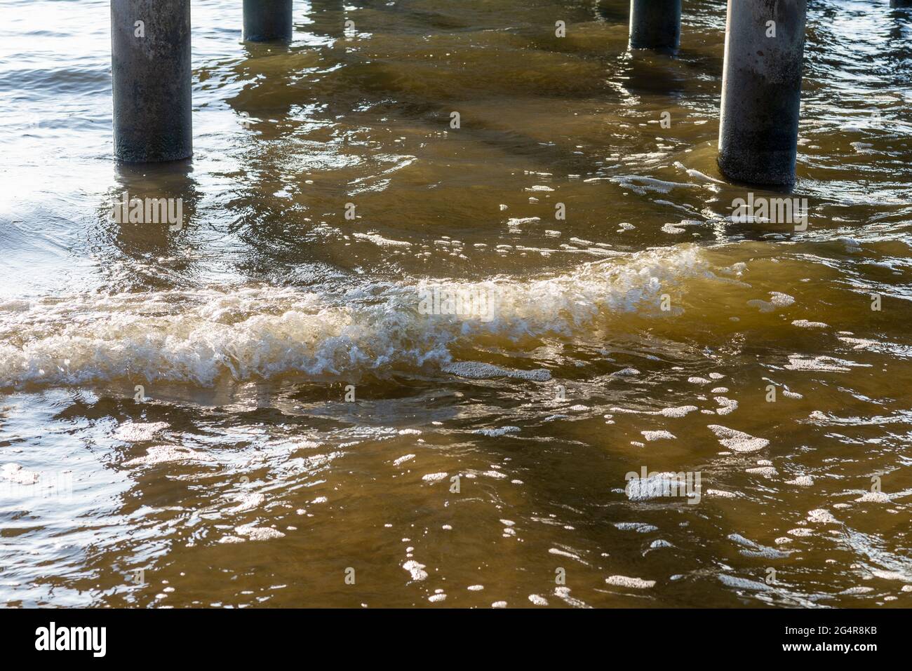 Columnar bridge piers at sunset.View under the bridge into sea with ...