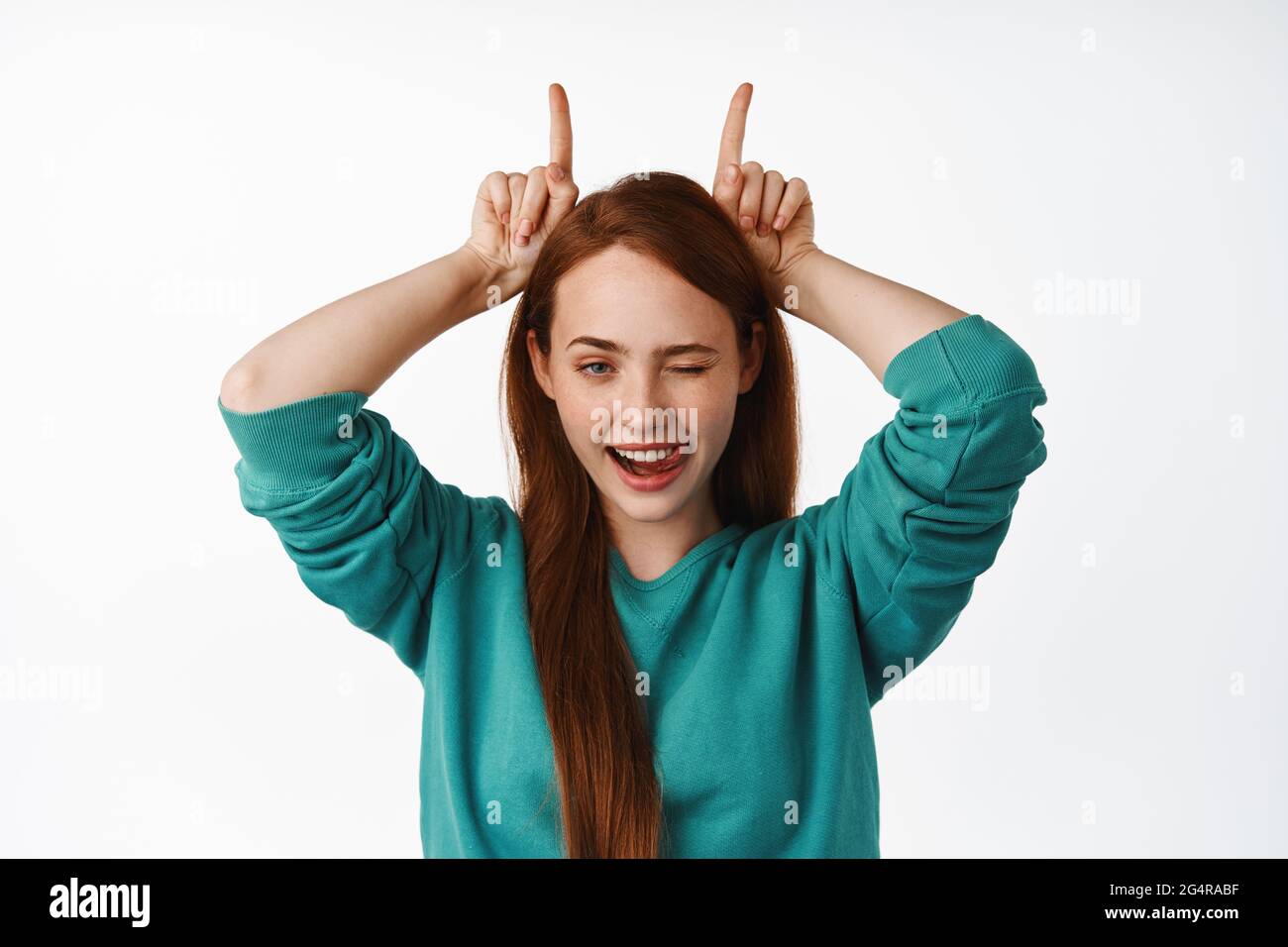 Close Up Portrait Of Sassy Redhead Girl Shows Bull Horns Gesture Winks