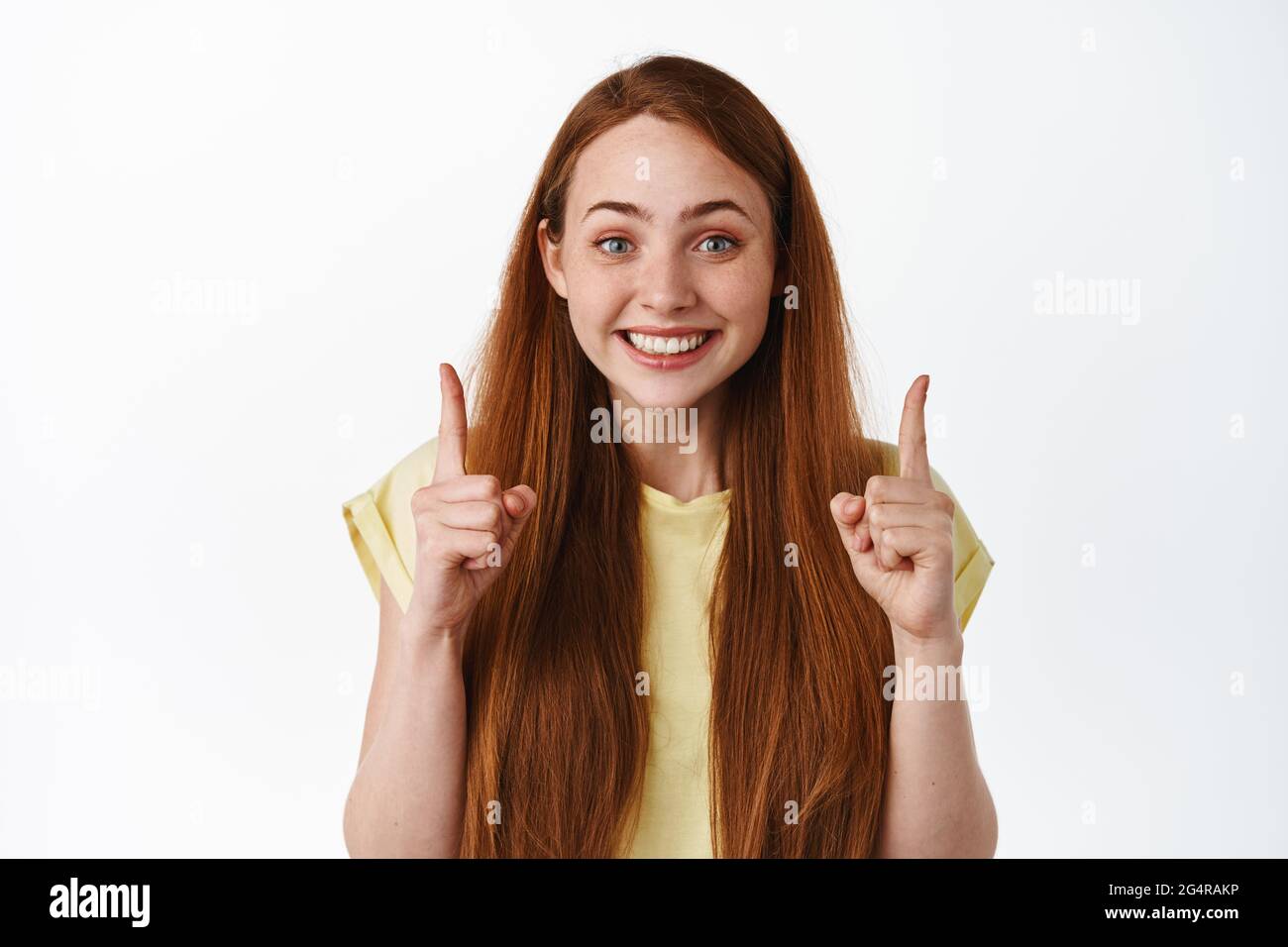 Close up portrait of smiling ginger girl with long hair, looking with ...