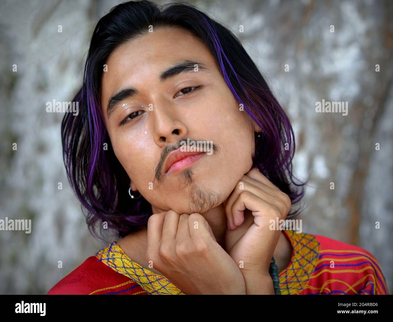 Handsome young Mexican man with dyed hair streak poses for the camera ...
