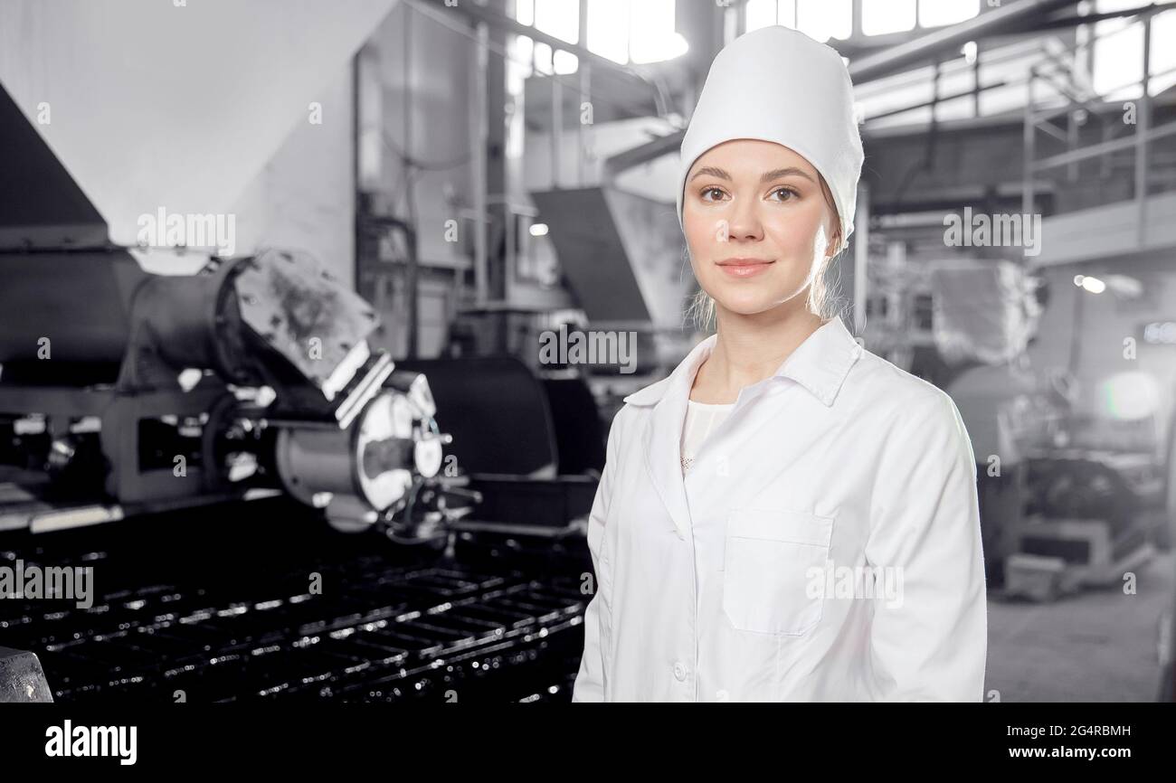 Baker woman holding fresh bread in hands on background automatic bakery ...