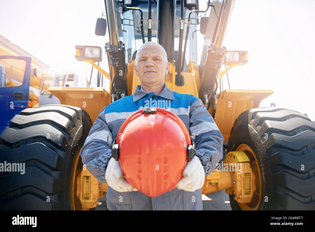 Bulldozer driver coal mine in uniform with helmet and headphones ...