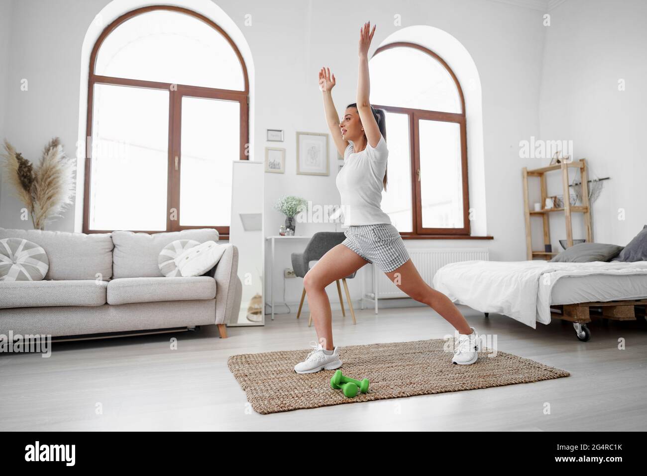 Young fitness girl doing sport exercises at her living room at home ...
