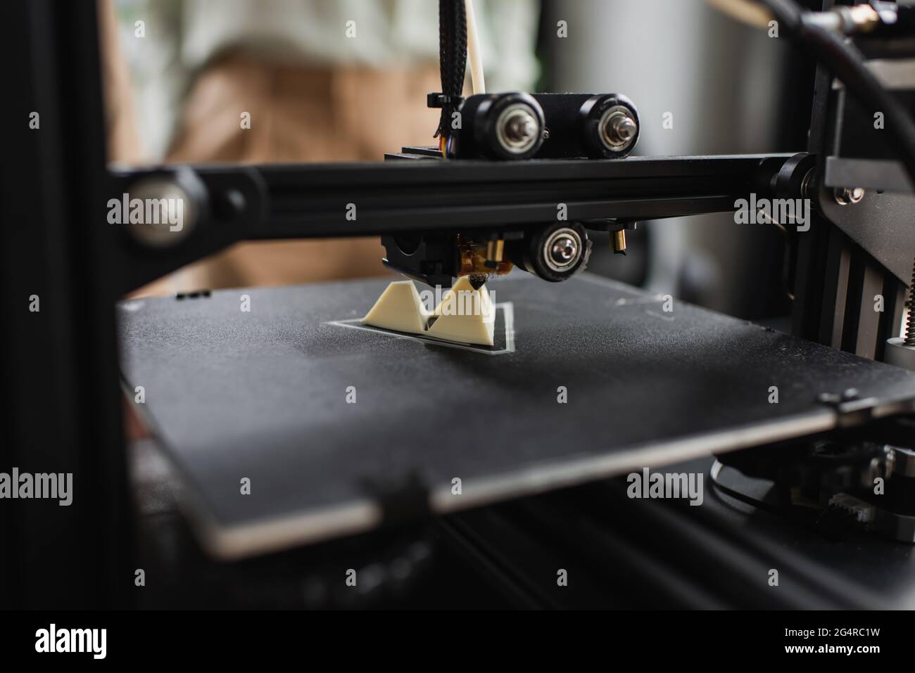 close up view of 3D printer creating plastic figure in modern office ...