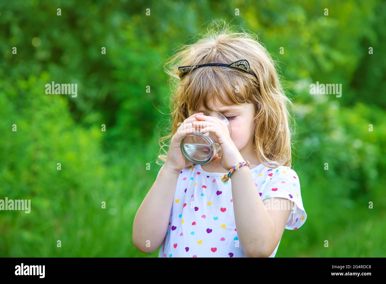 Child girl drinks water from a glass. Selective focus. Kid Stock Photo - Alamy