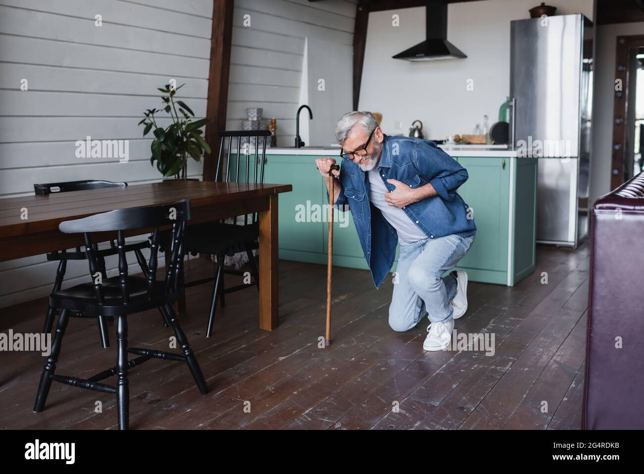 Sick man with crutch holding hand on chest while falling on floor Stock ...