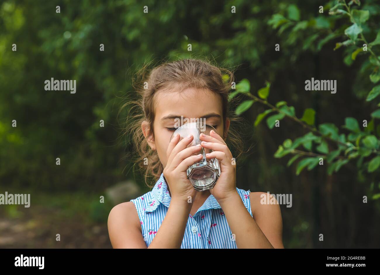 Child girl drinks water from a glass. Selective focus. Kid Stock Photo - Alamy