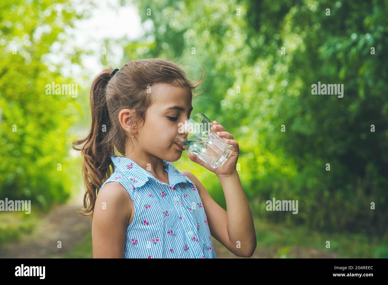 Child girl drinks water from a glass. Selective focus. Kid Stock Photo - Alamy