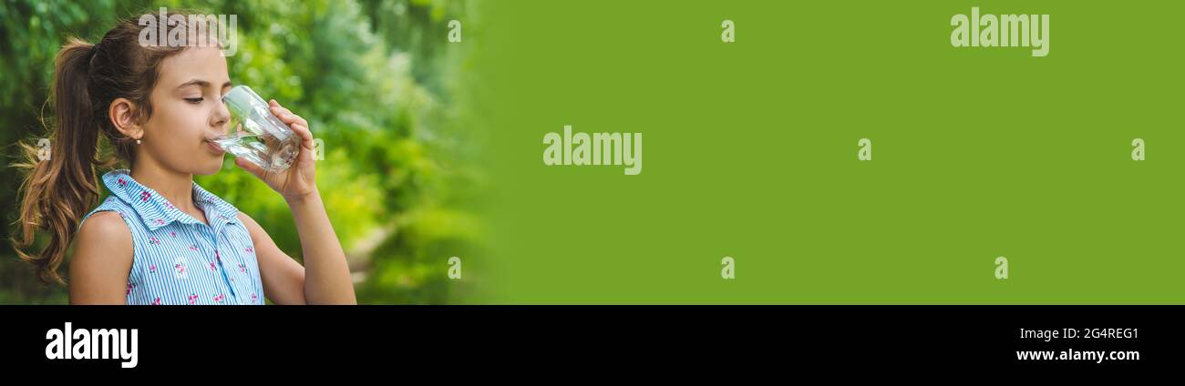 Child girl drinks water from a glass. Selective focus. Kid Stock Photo - Alamy