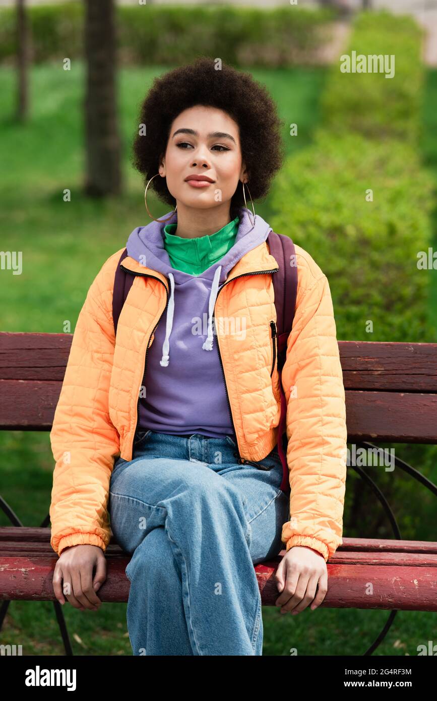 Pretty african american woman sitting on bench outdoors Stock Photo - Alamy