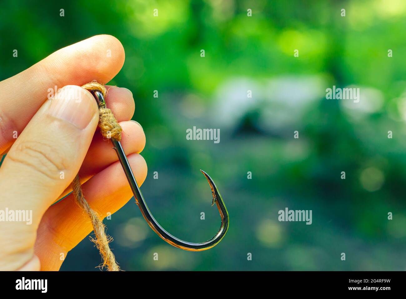 Sharp fishing hook. Steel hook in hand. Fish trap Stock Photo - Alamy