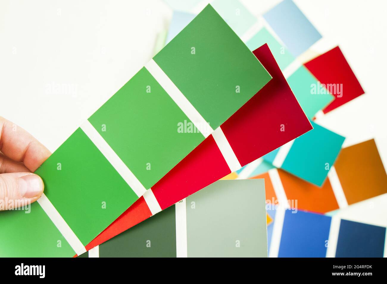 Closeup shot of a hand holding gradient color charts, trying to pick ...