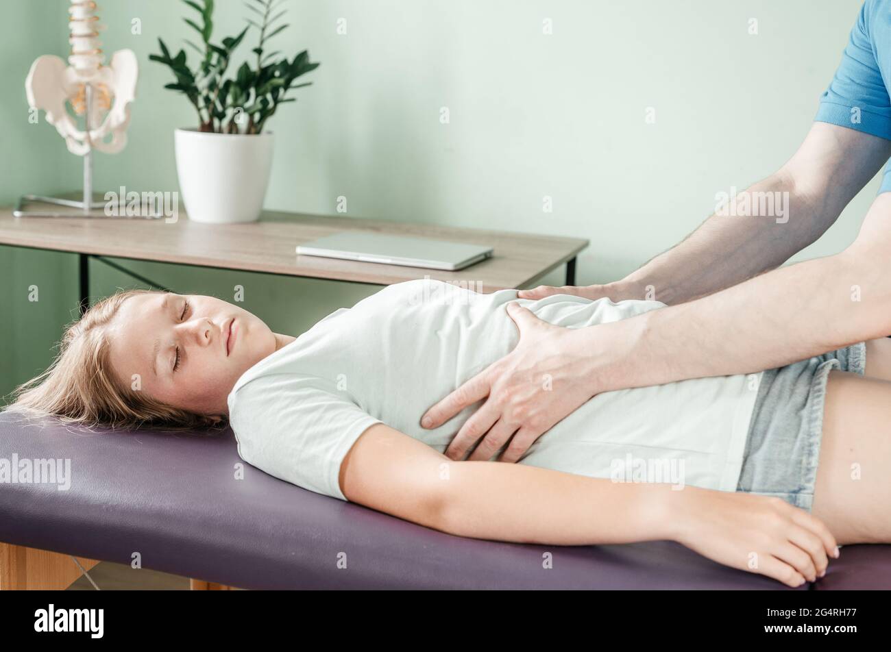 Osteopath practitioner releasing the diaphragm of a female patient, rib ...