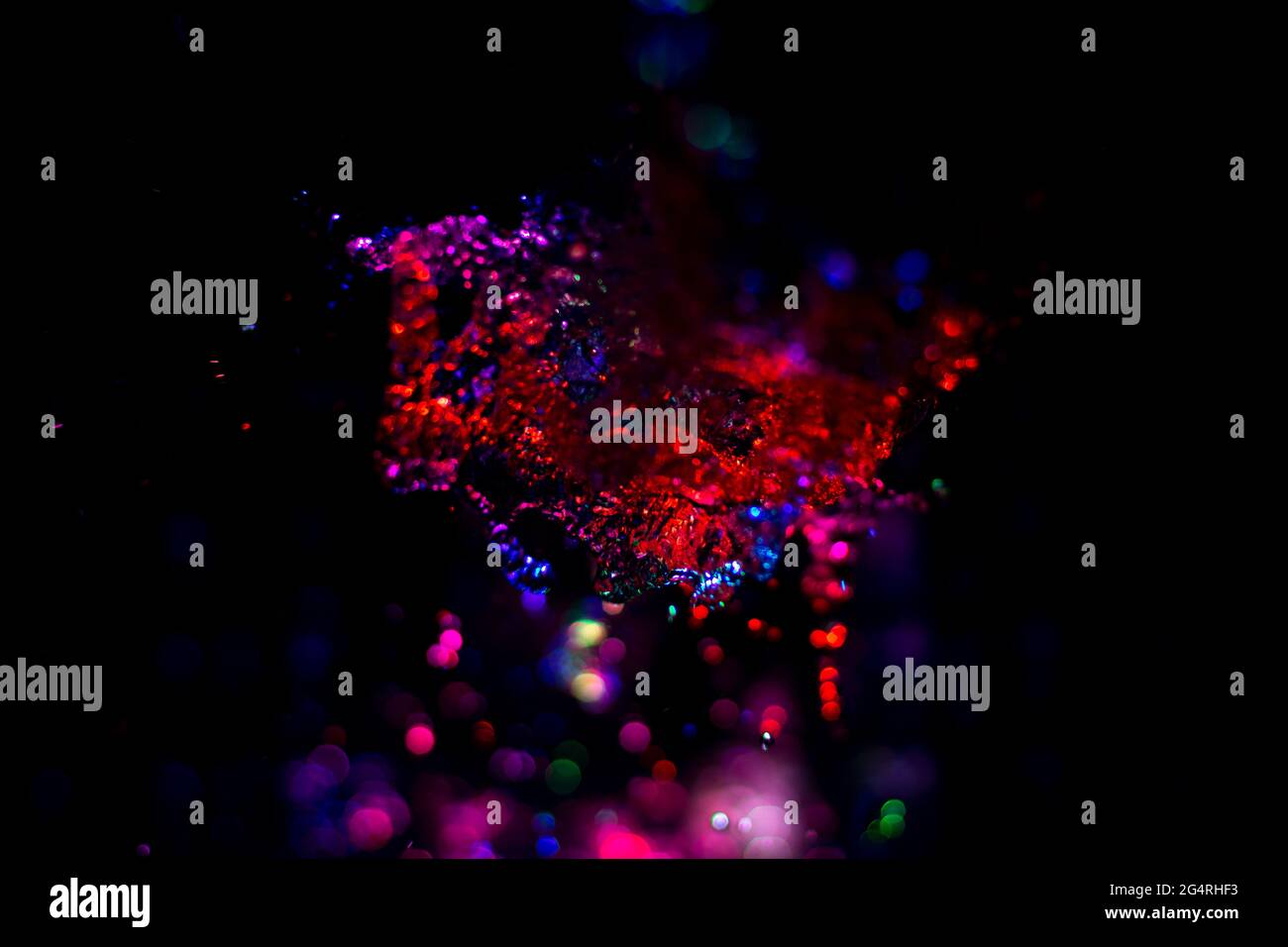 Colored water texture. Splashes of water lit in different colors. Close ...