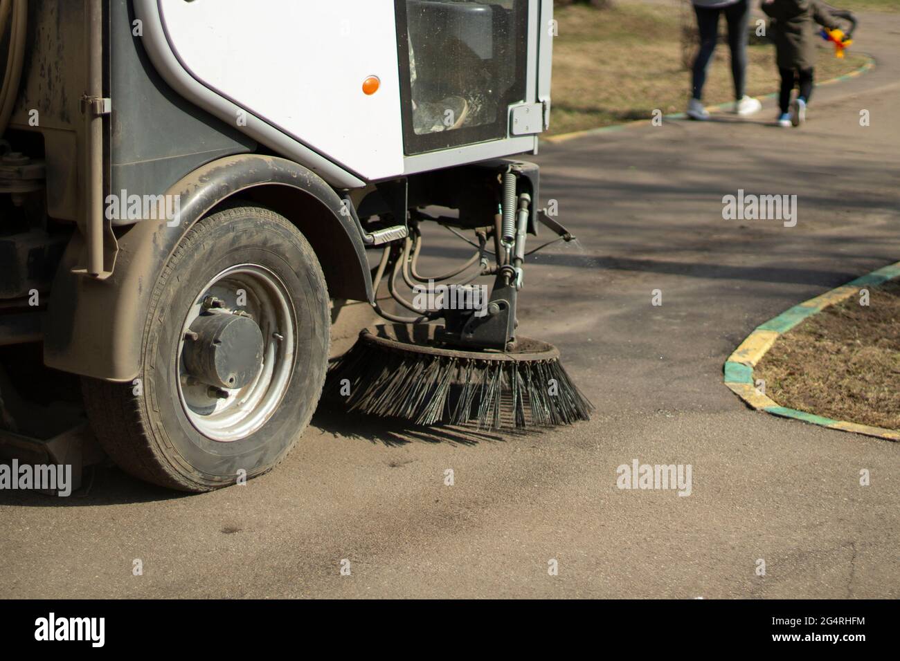 The sweeper is sweeping the asphalt. Cleaning the path with a cleaning ...