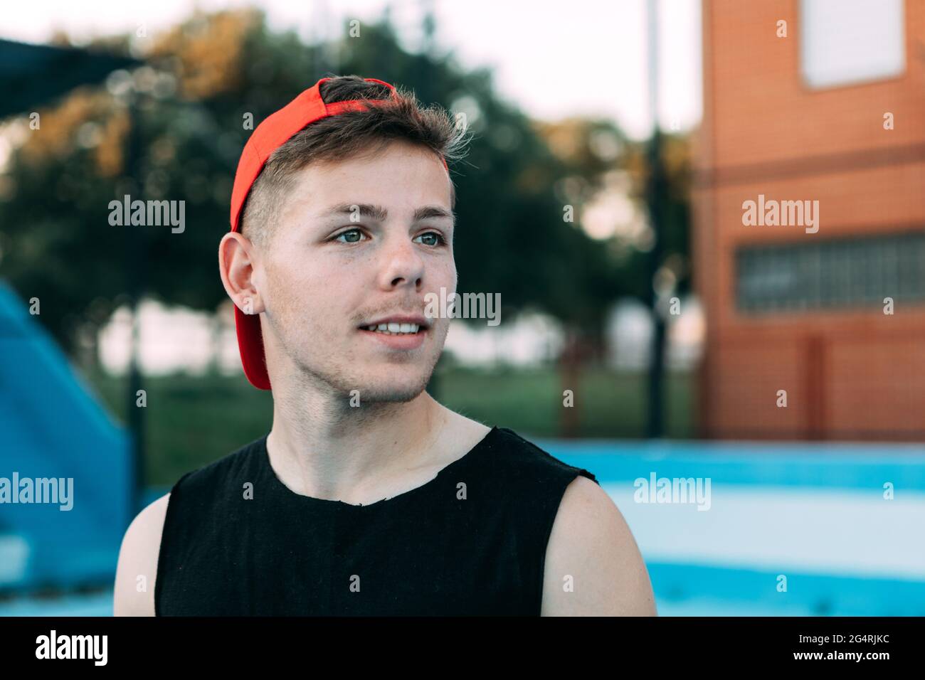 Young guy with red cap outside Stock Photo - Alamy